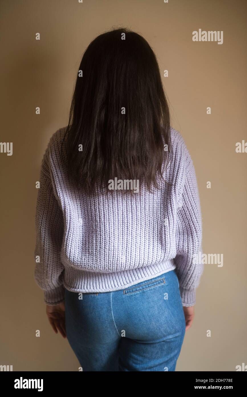 Rear view of young woman standing indoors Stock Photo - Alamy