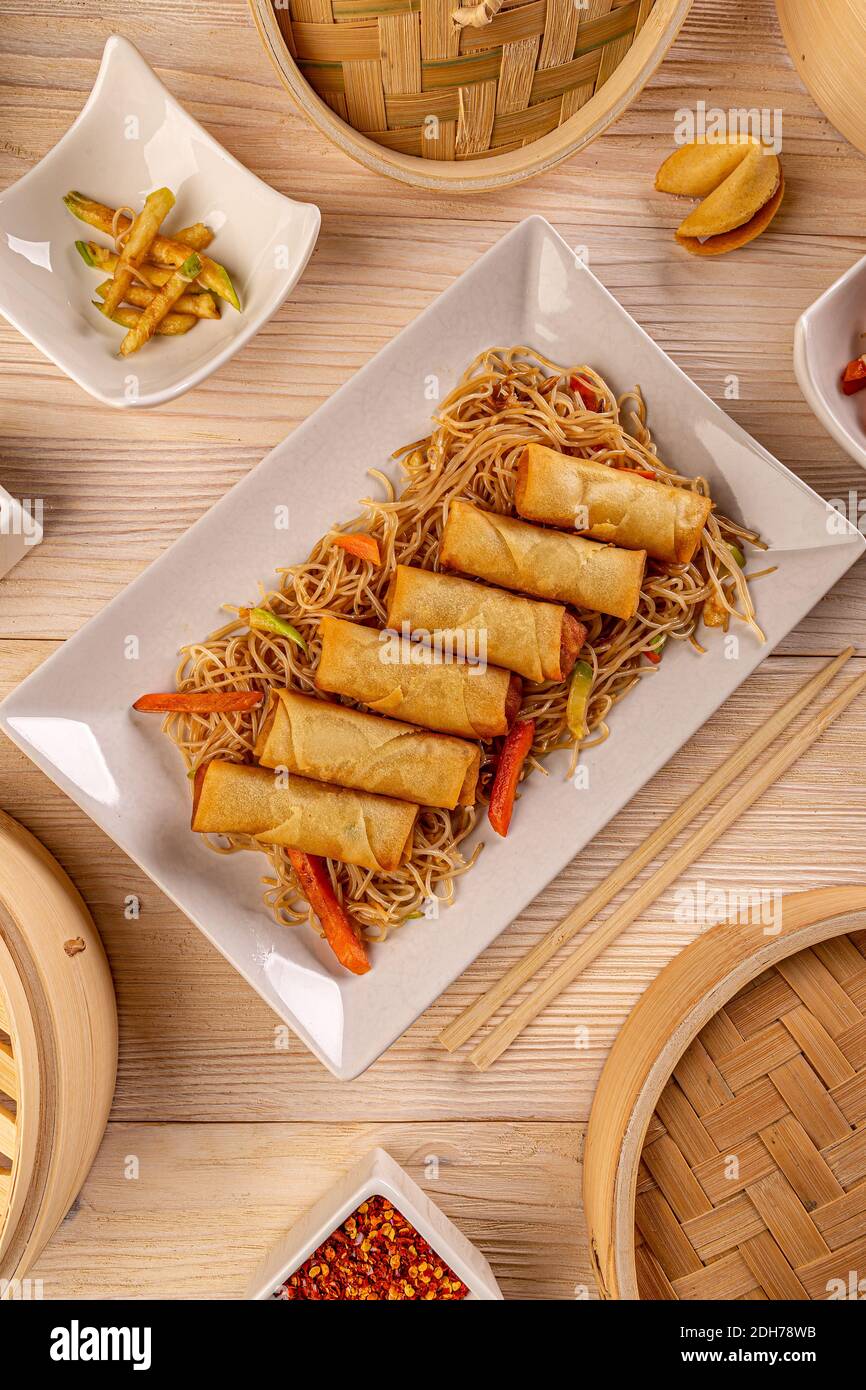 Spring rolls in white dish with noodles on the wooden background Stock ...