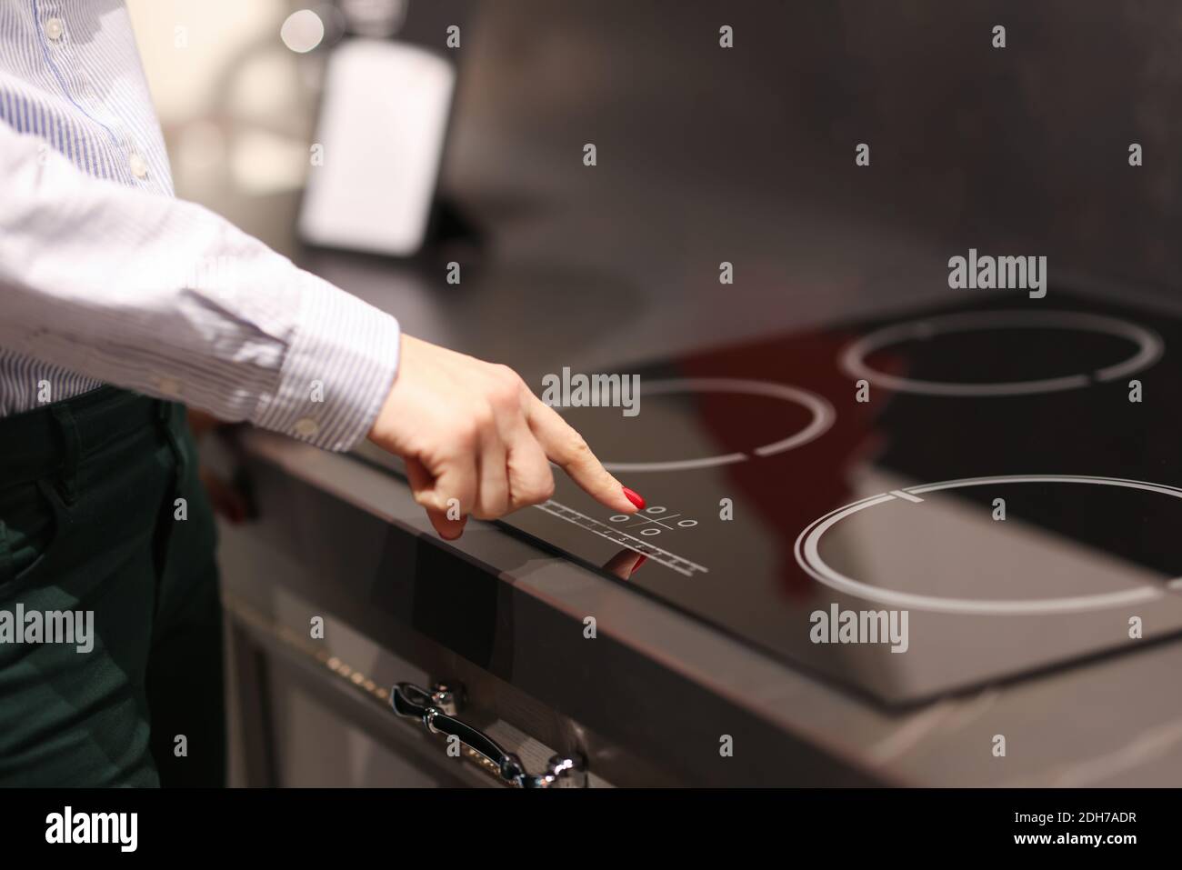 Female finger presses button on touch electric stove Stock Photo - Alamy