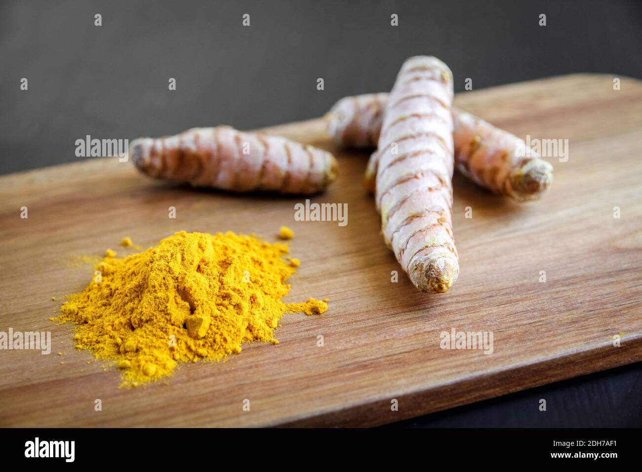 Turmeric root and spice powder on a cutting board Stock Photo - Alamy