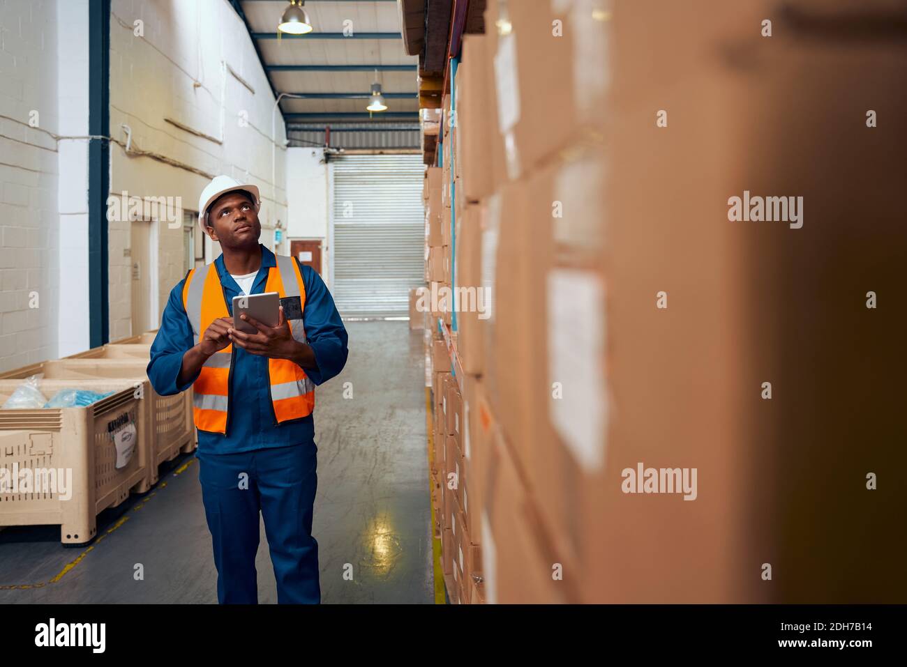 African American factory worker checking stock inventory using digital ...