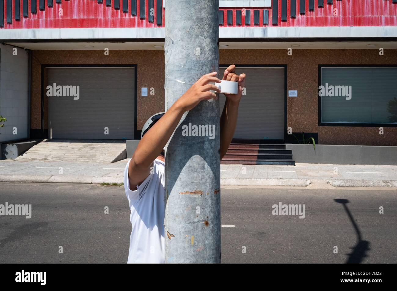 Man taping a pole on the street, Phuoc Hai, Vietnam Stock Photo - Alamy