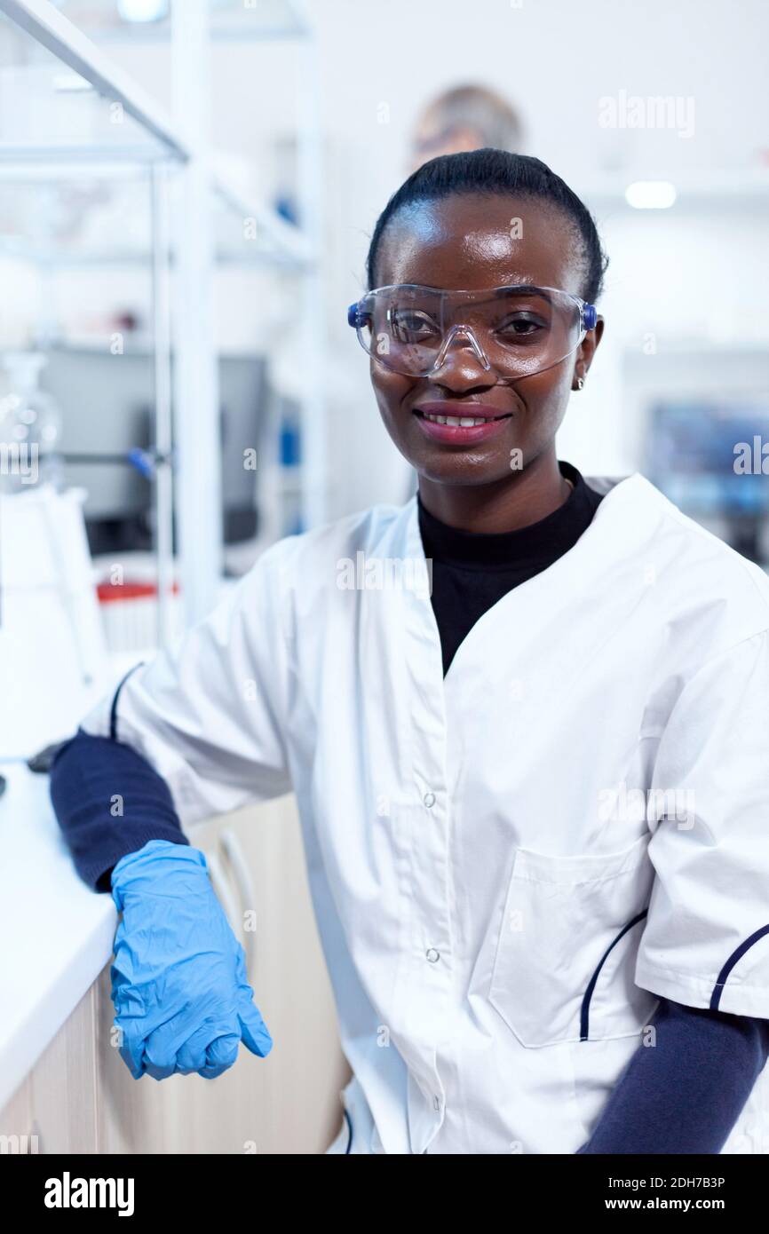 African scientist wearing protective glasses in medical laboratory ...