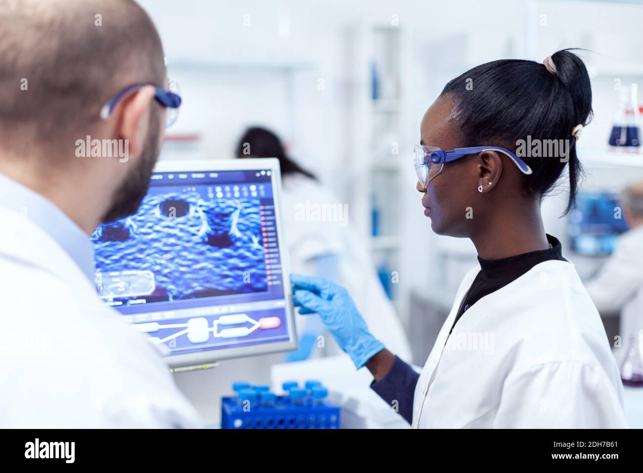 Serious african scientist standing using computer for medical ...