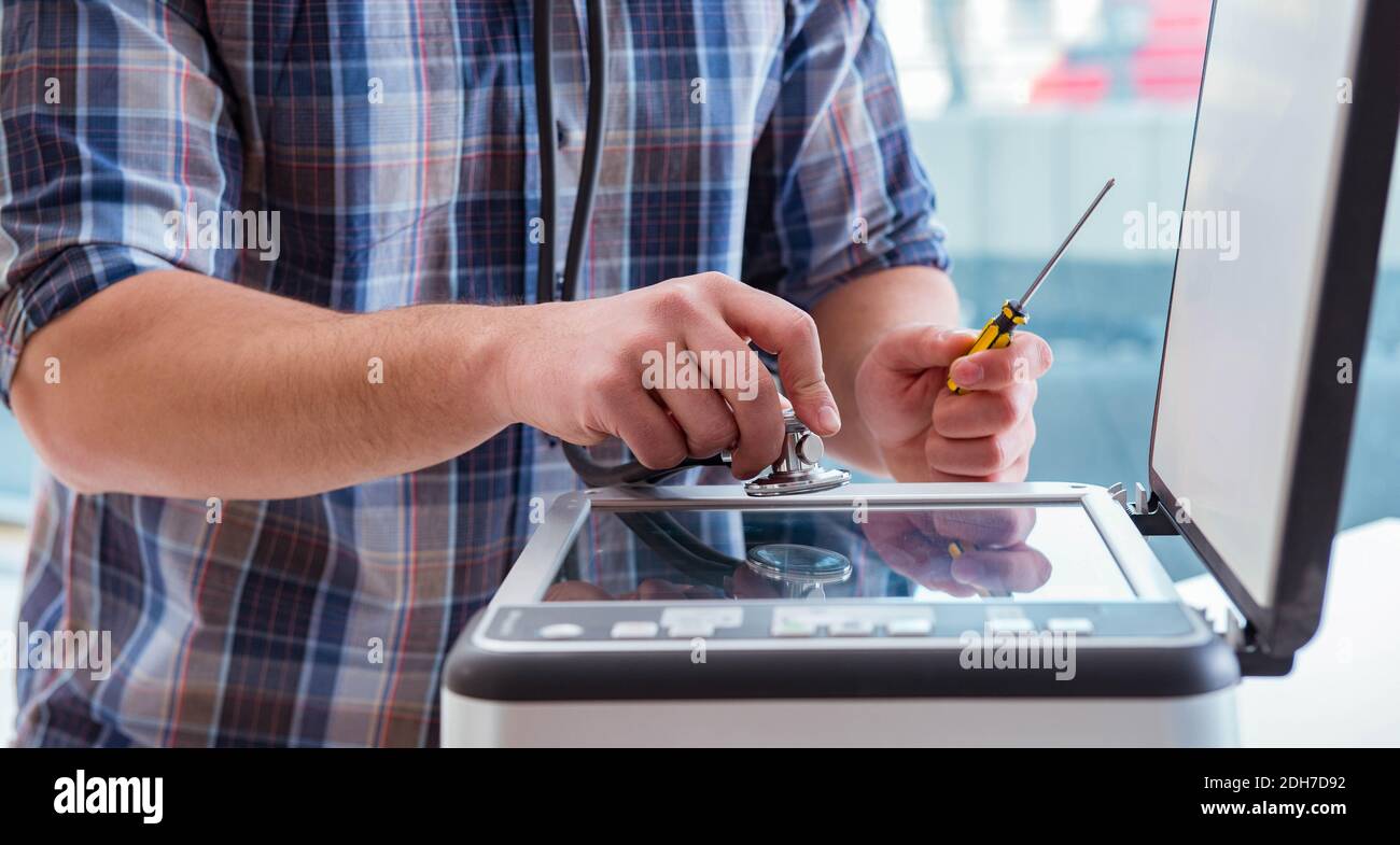 Repairman repairing broken color printer Stock Photo - Alamy
