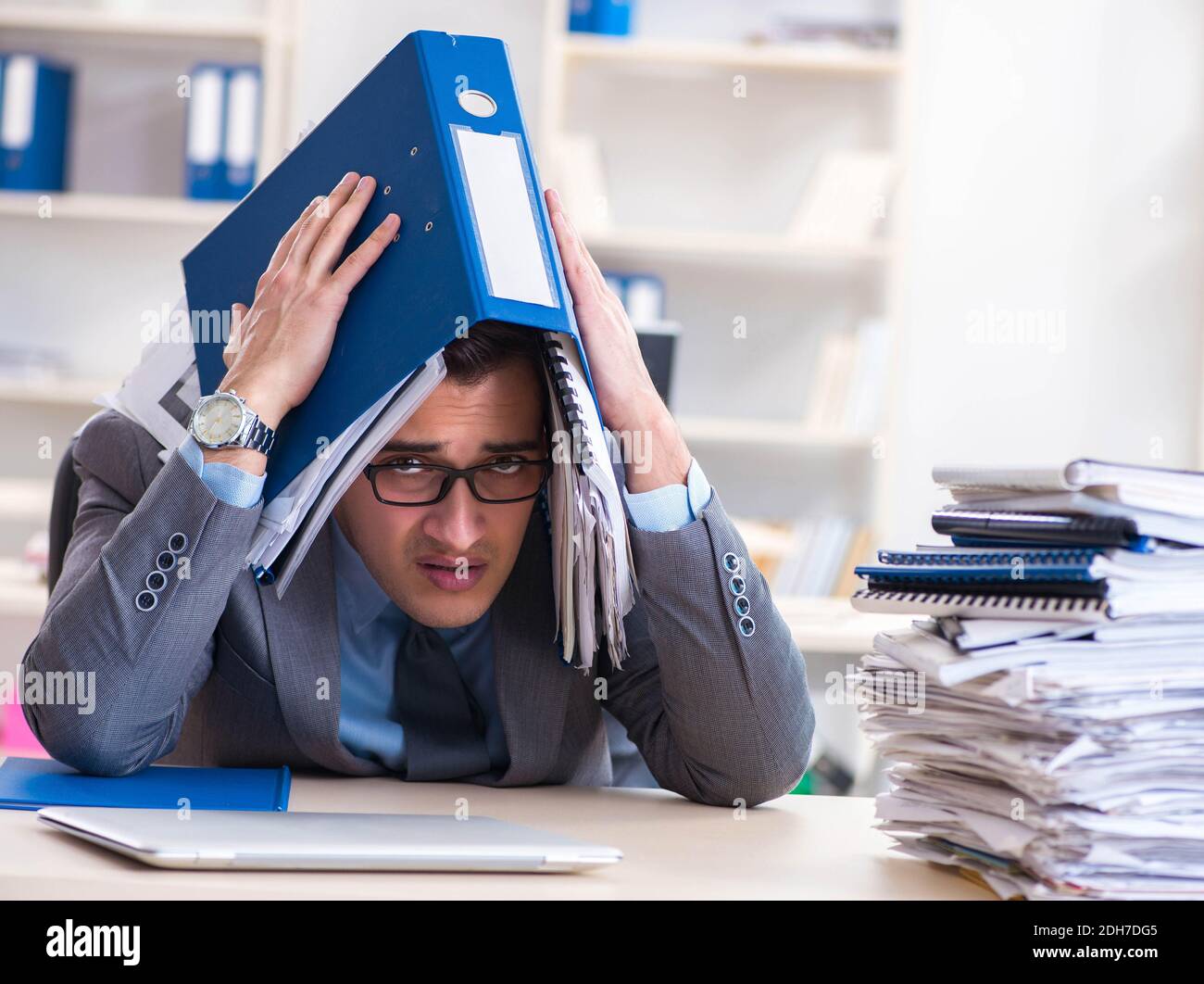 Overloaded with work employee under paperwork burden Stock Photo - Alamy