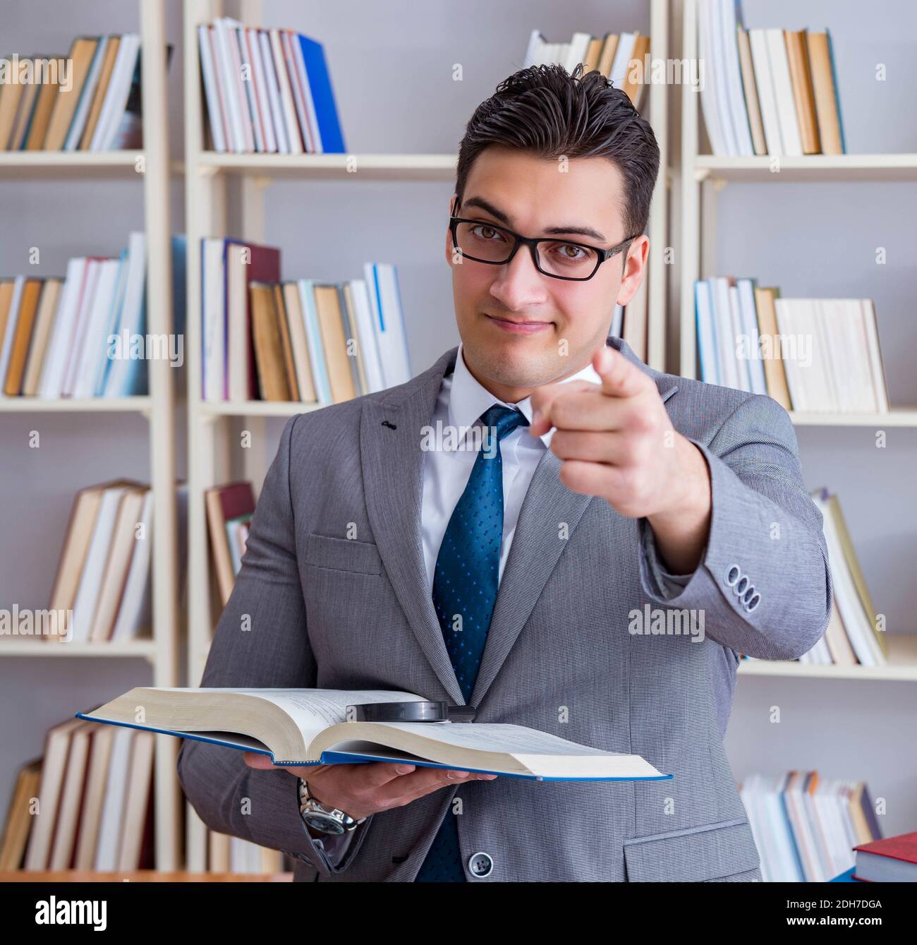Business law student with magnifying glass reading a book Stock Photo ...