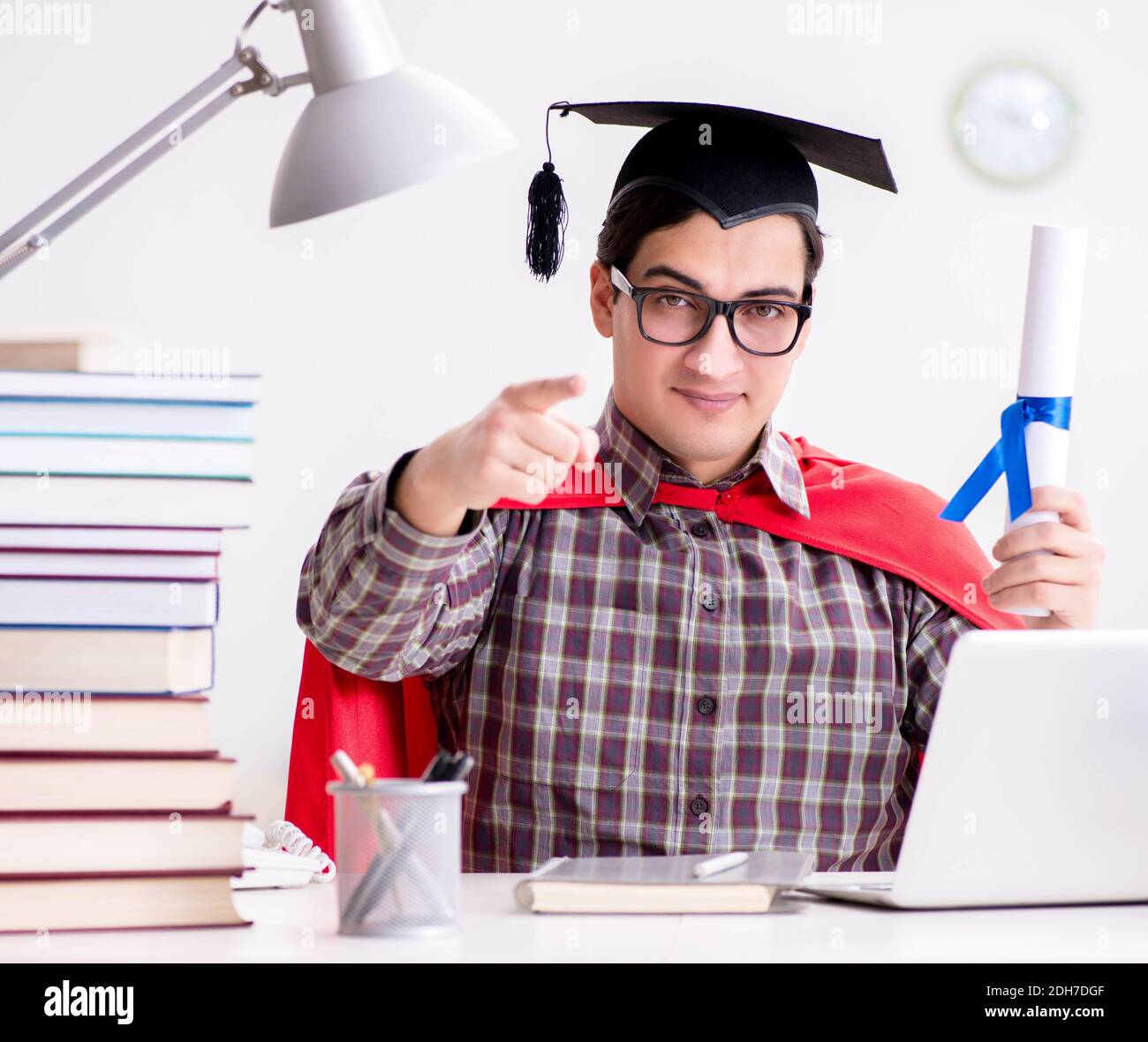 Super hero student wearing a mortarboard studying Stock Photo - Alamy