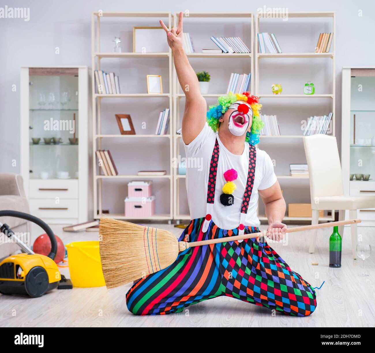 Funny clown doing cleaning at home Stock Photo - Alamy