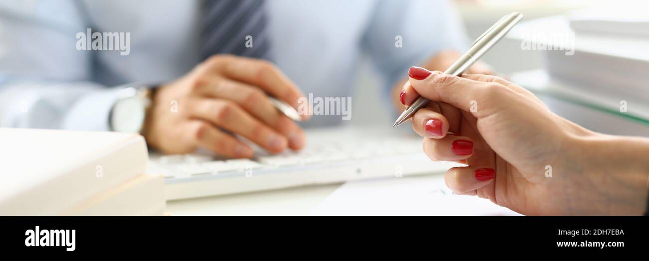 Female hand holds ballpoint pen over documents closeup in front of man ...