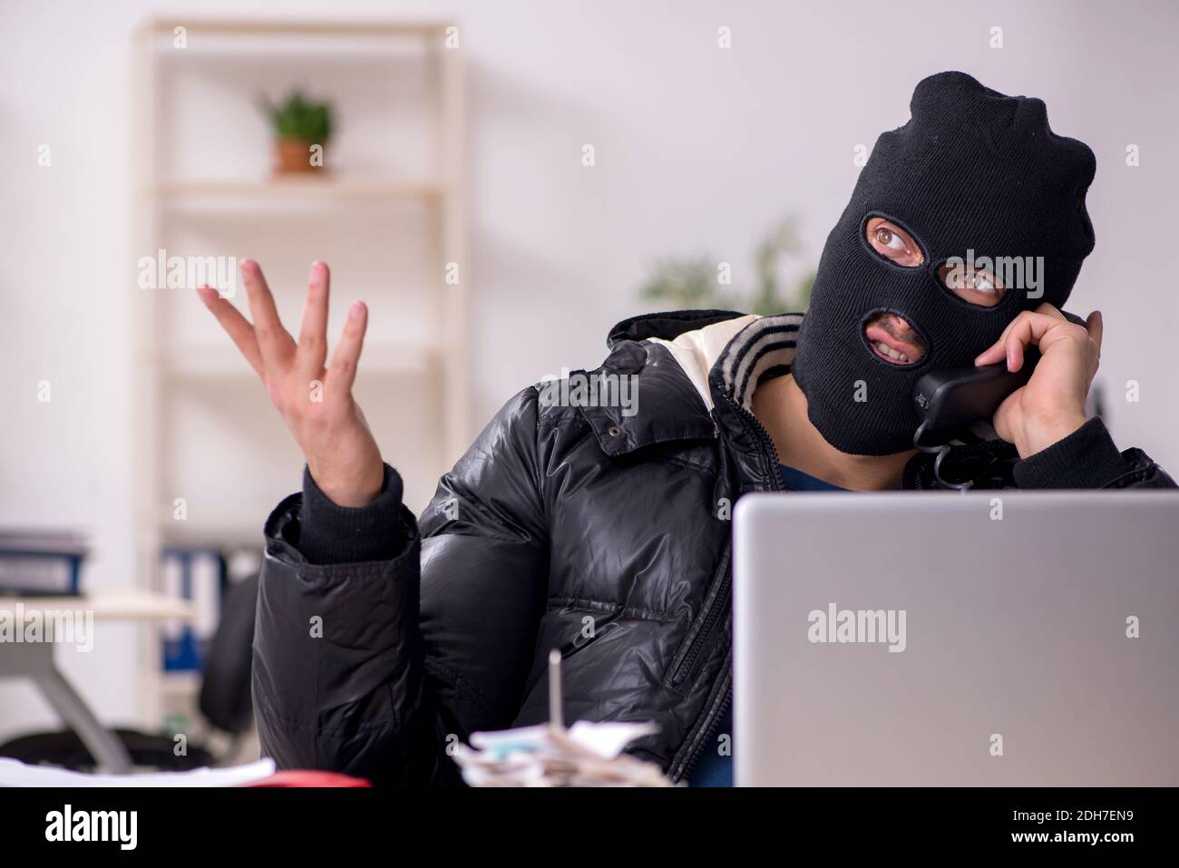 Young male burglar in the office Stock Photo - Alamy