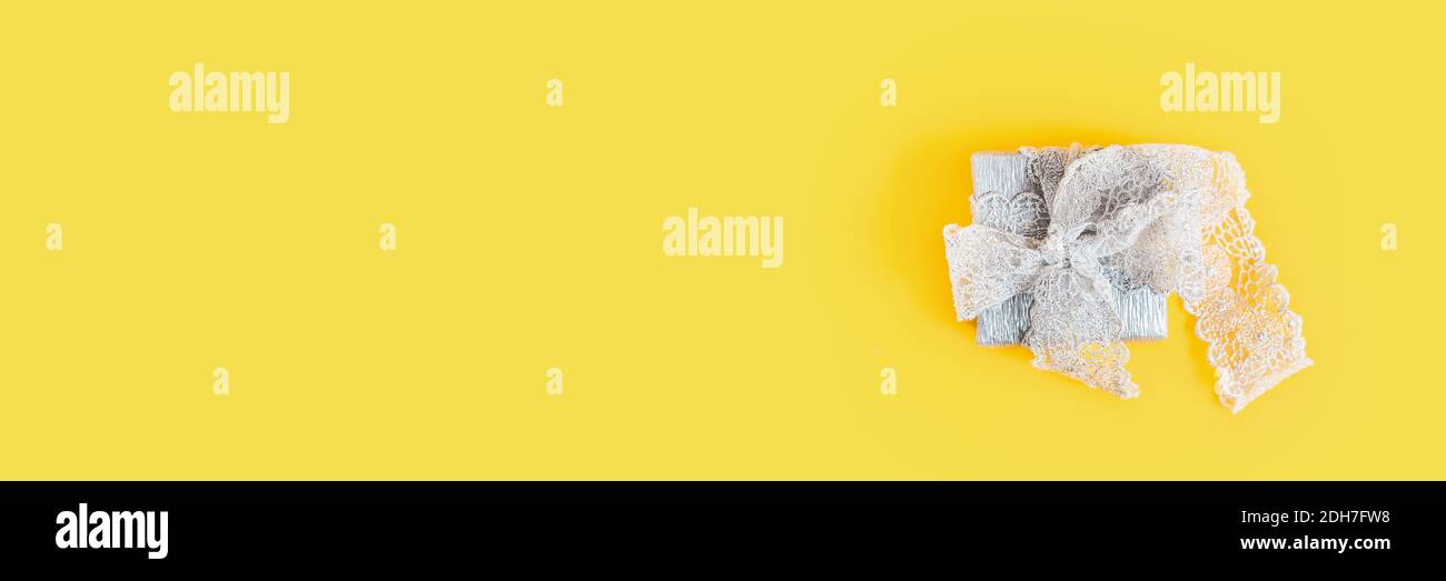 Gray color gift box on bright yellow background. Long banner with copy ...
