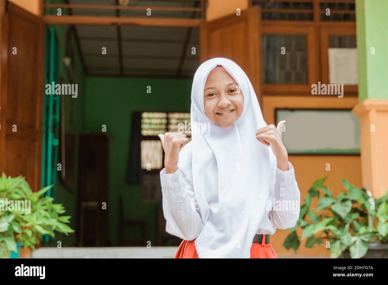 primary student wearing school uniform showing thumbs up to camera ...