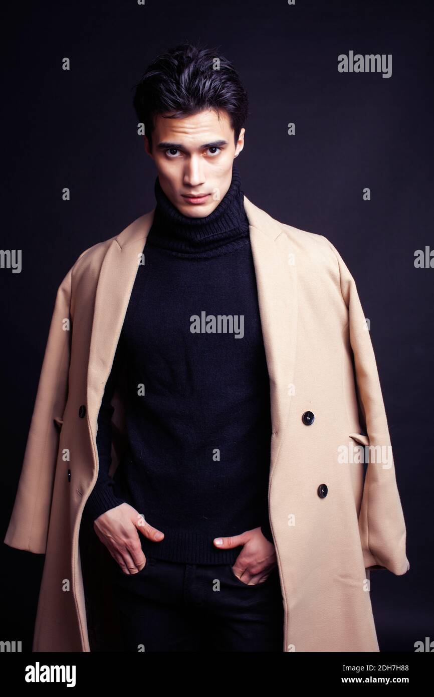 handsome asian fashion looking man posing in studio on black background ...