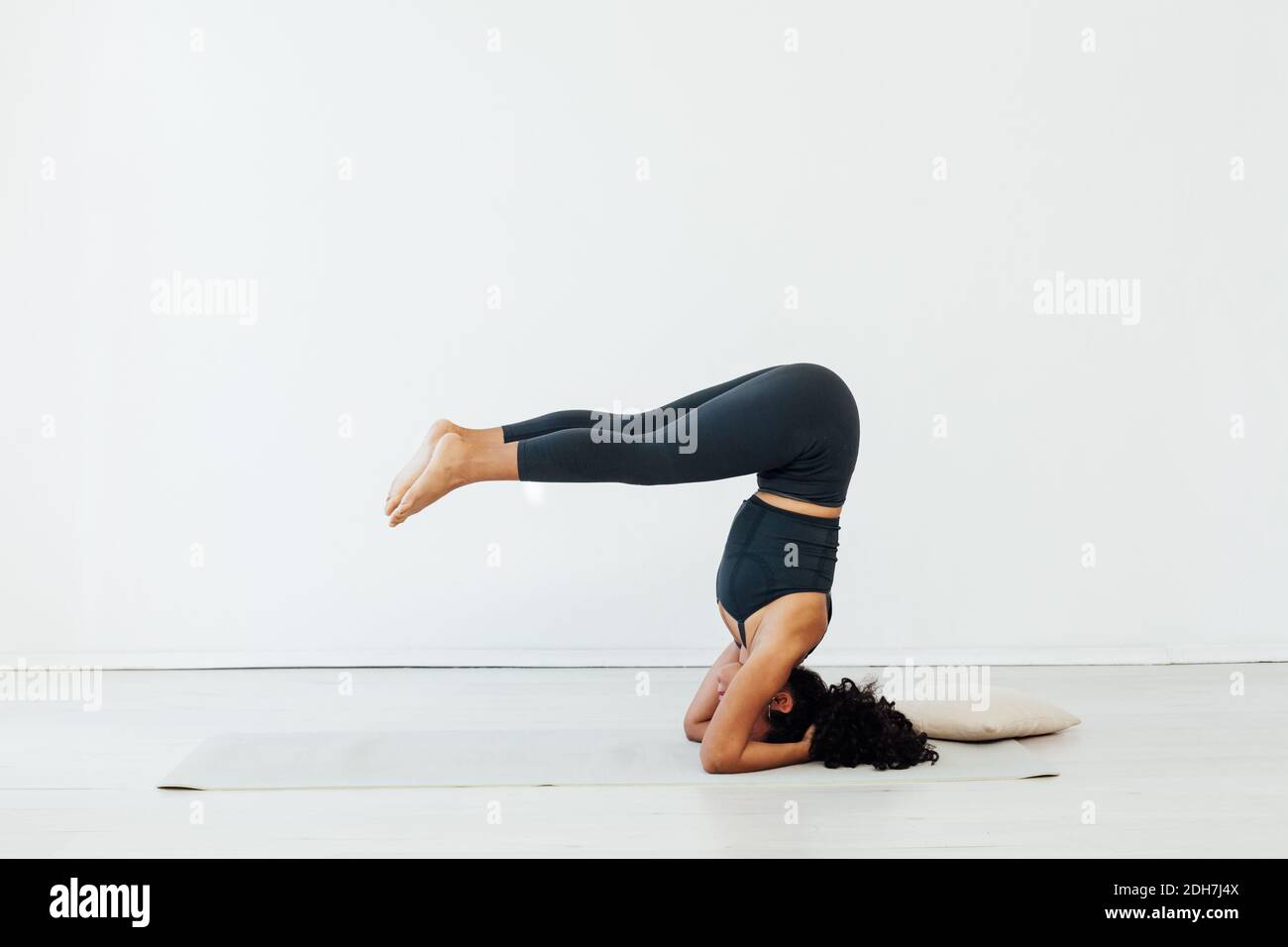 female yoga asana gymnast stands on her head Stock Photo - Alamy