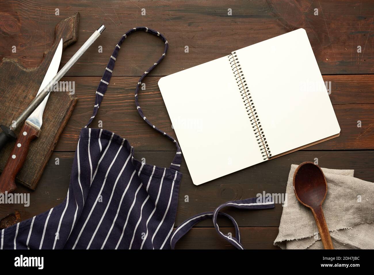 Open notebook with blank white sheets and kitchen utensils on brown ...