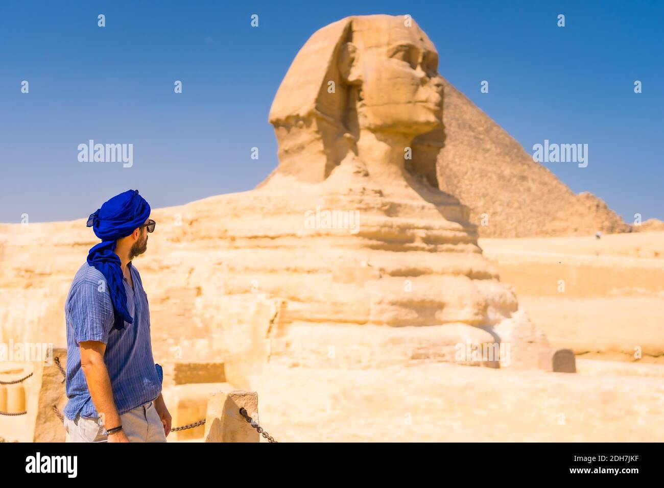 A young tourist wearing a blue turban standing at the Great Sphinx of ...