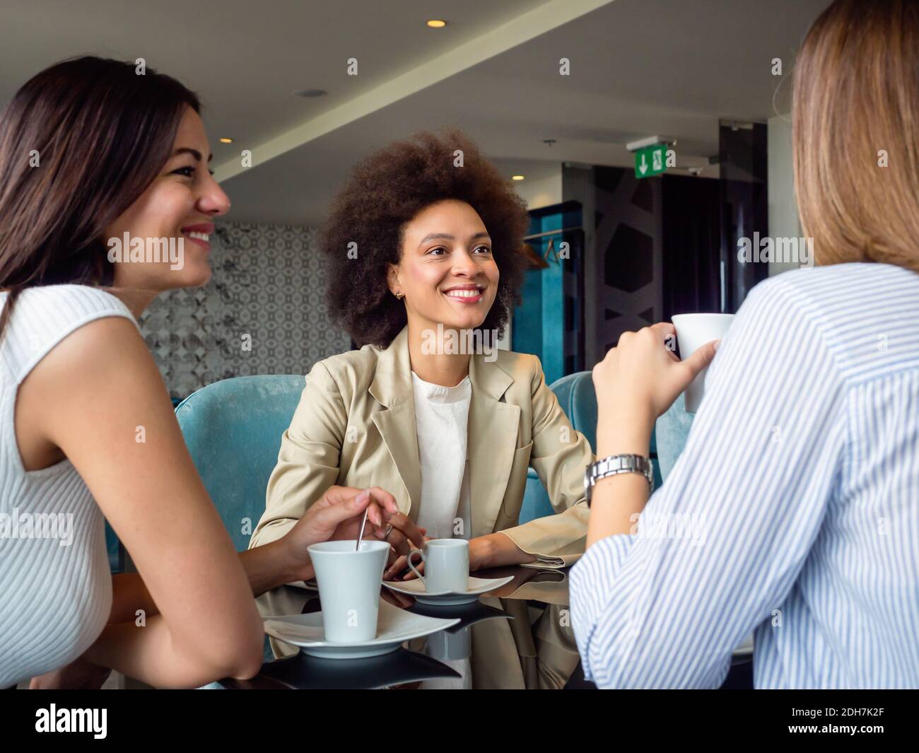 Successful attractive women friends chatting in cafe during coffee ...