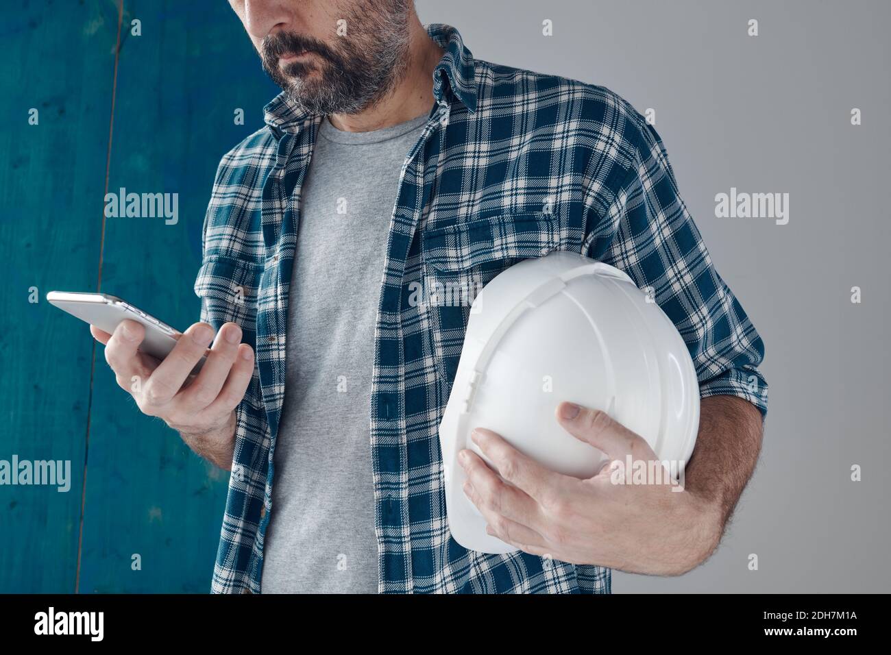 Construction engineer using mobile phone on a morning break, relaxing ...