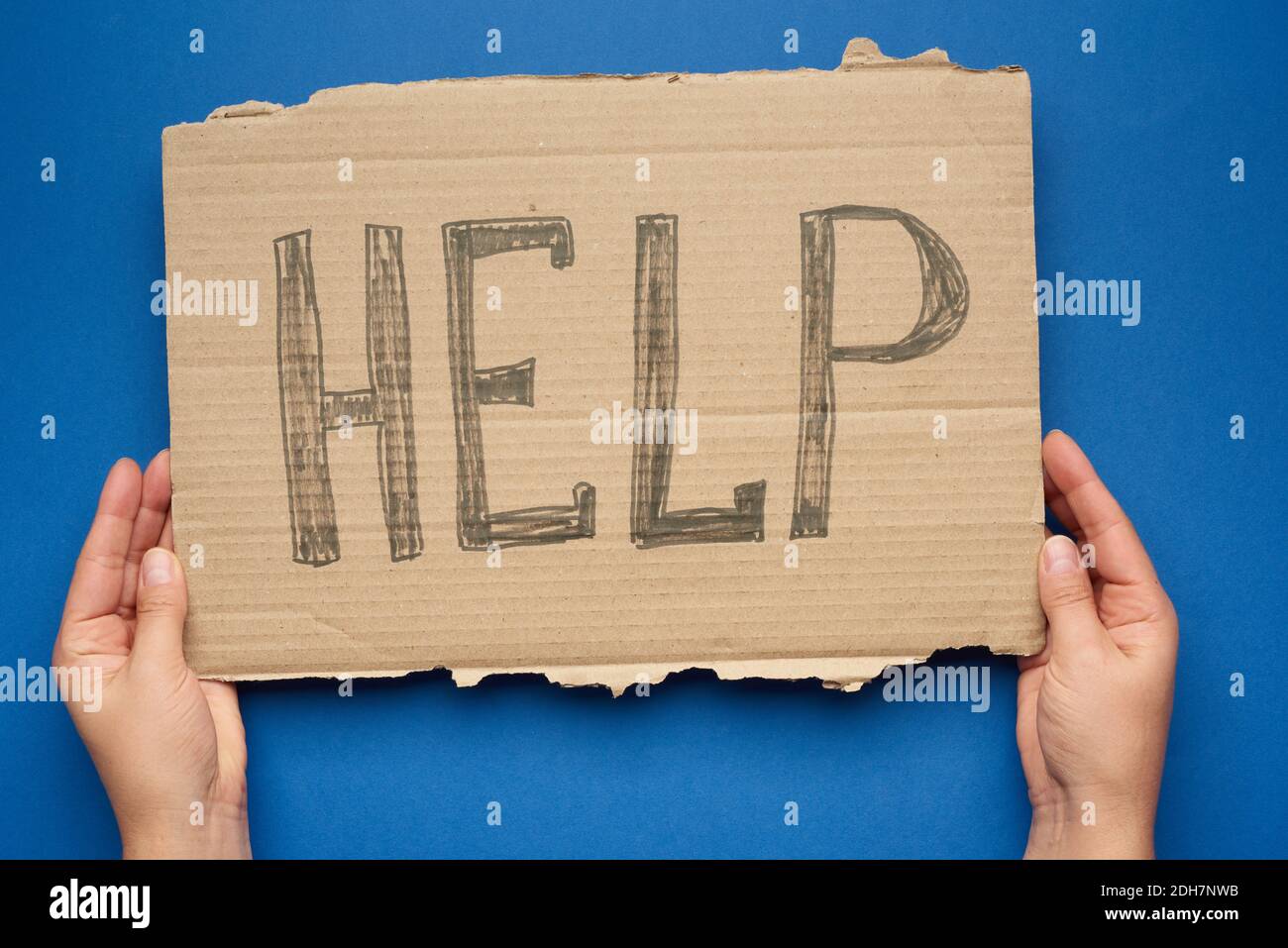 Hand holds a piece of cardboard with the inscription help, mutual ...