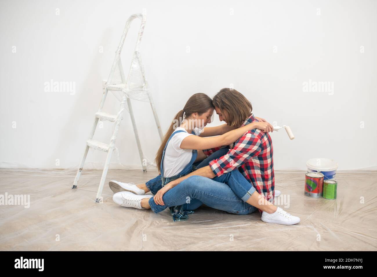 Happy couple sitting on the floor and hugging each other Stock Photo ...