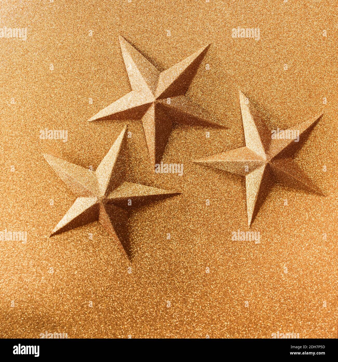 Three golden stars on golden background Stock Photo - Alamy
