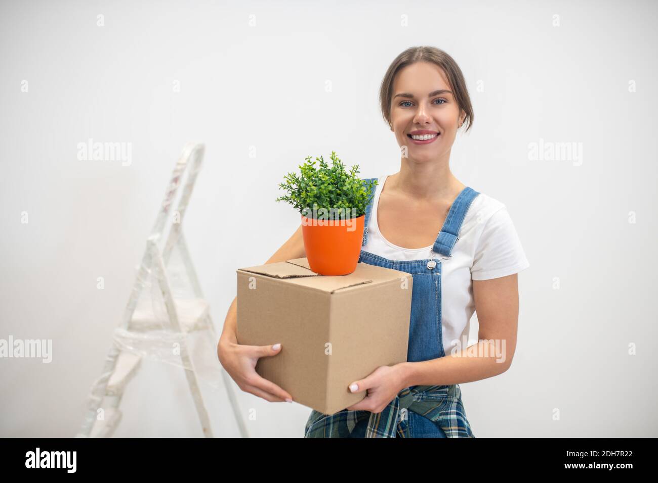 Long-haired woman holding boxes in hands and smiling Stock Photo - Alamy