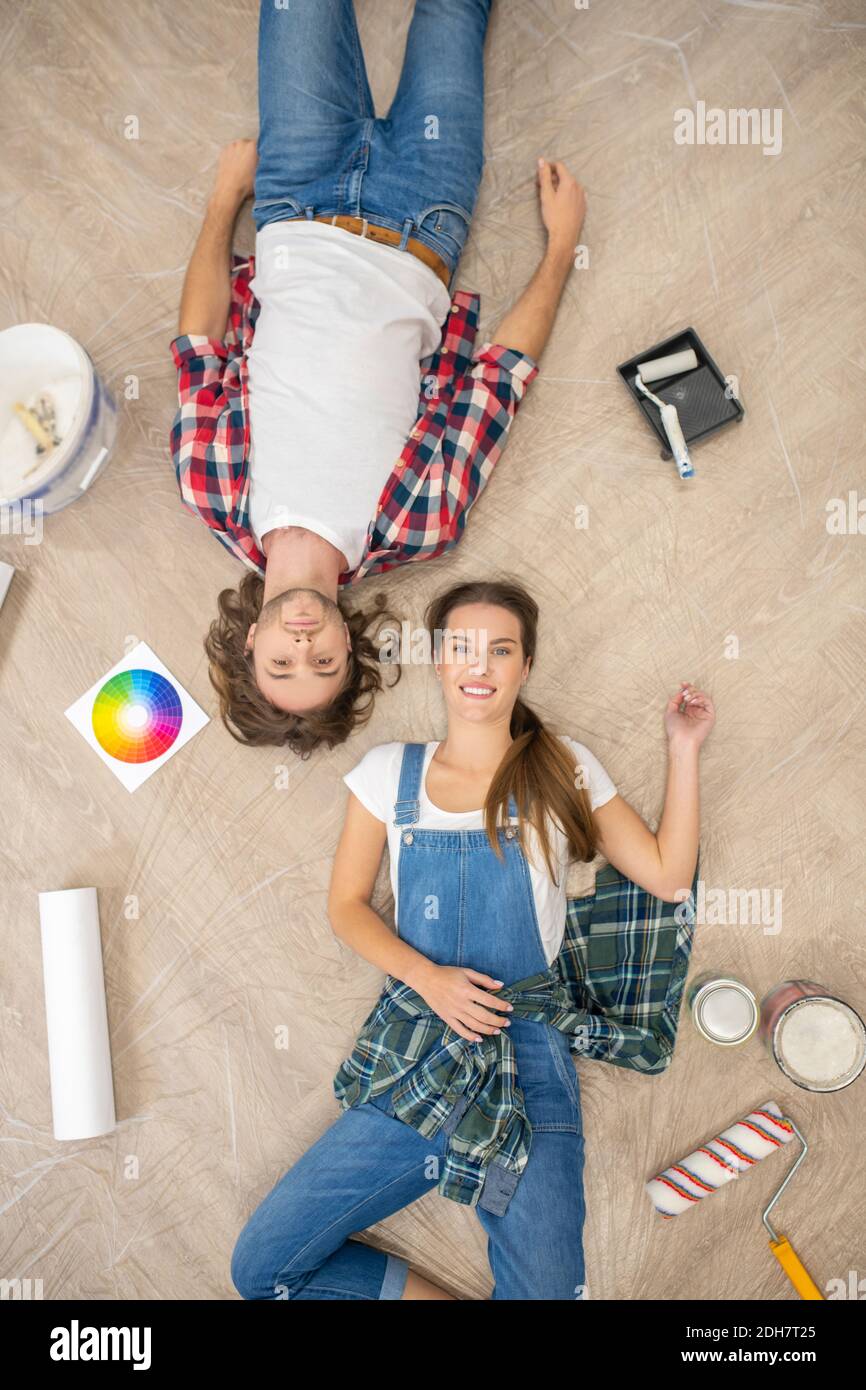 Young couple lying on the floor and resting after work Stock Photo - Alamy