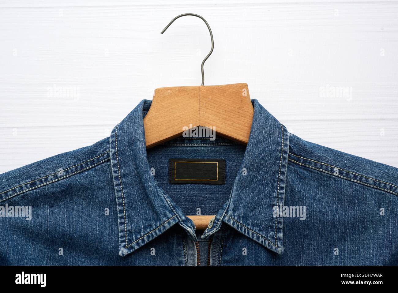 Blue denim shirt hanging on vintage wooden hanger, white background ...