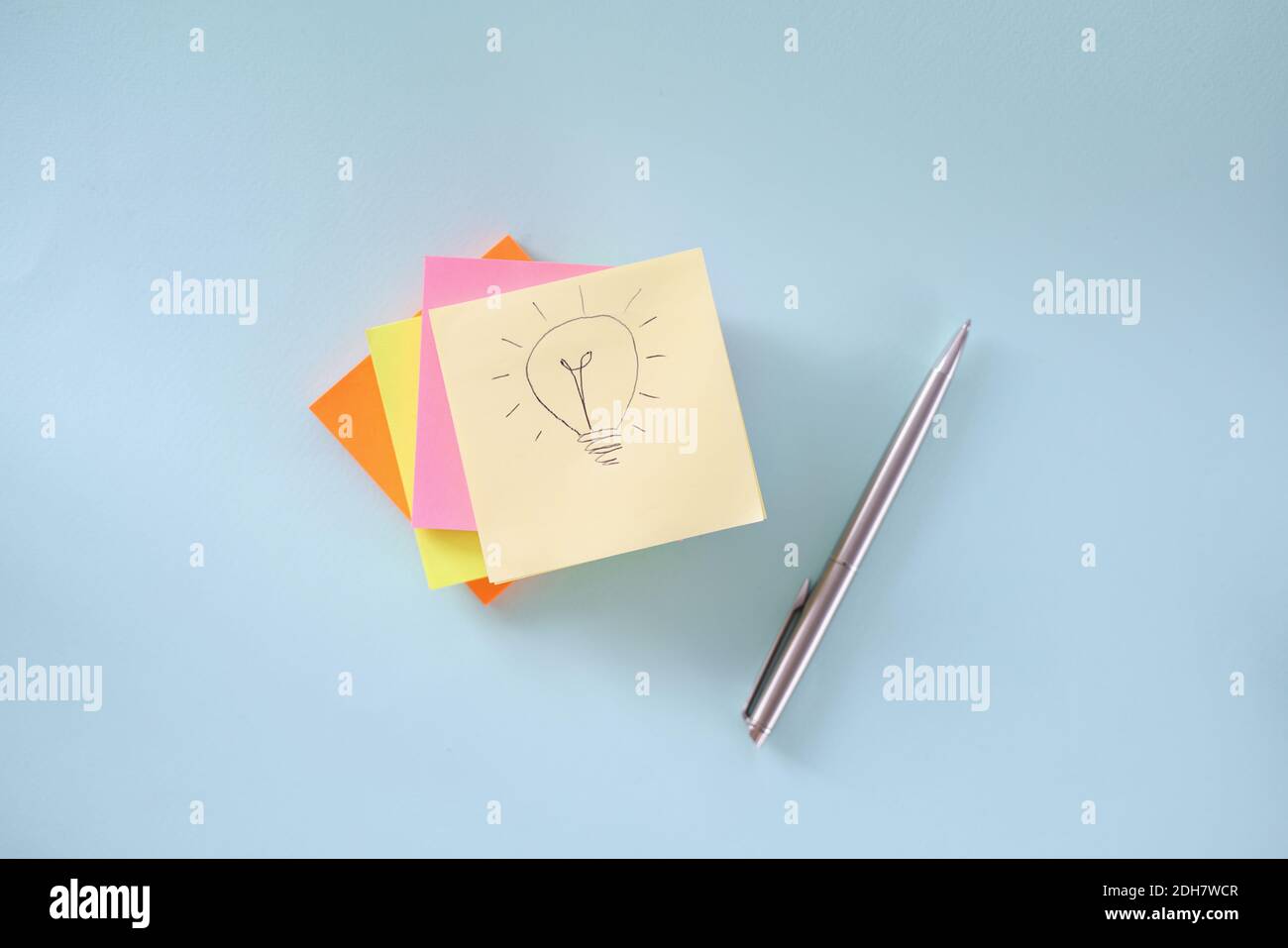 Light bulb is drawing on piece of paper. Many colorful stickers and ...