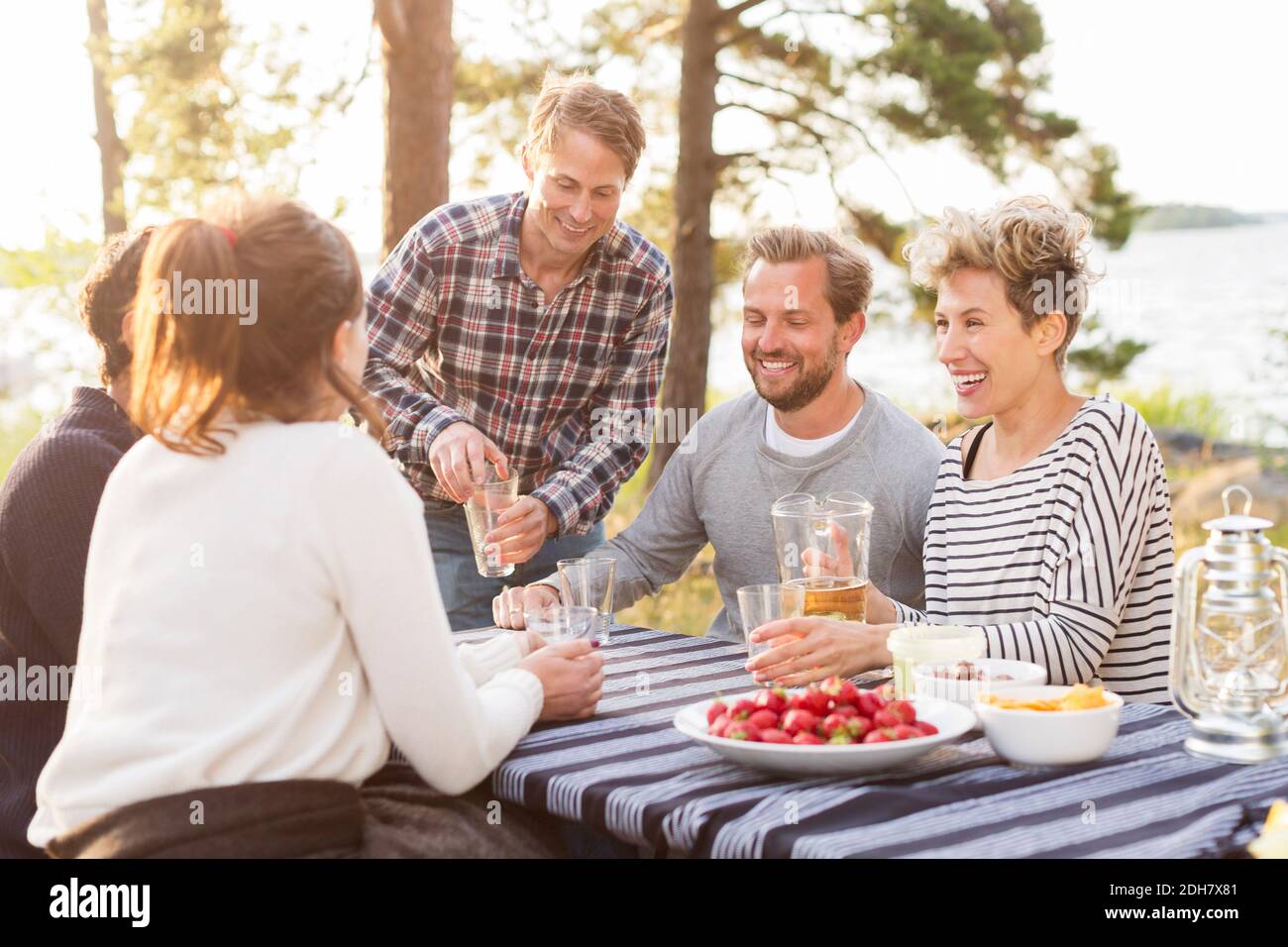 People enjoying while having lunch at lakeshore Stock Photo - Alamy