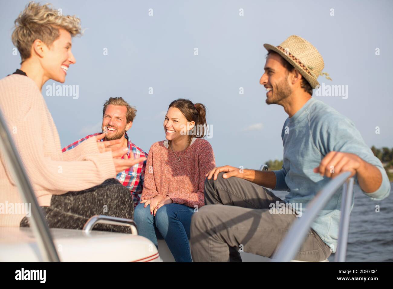 Happy friends communicating on yacht Stock Photo - Alamy