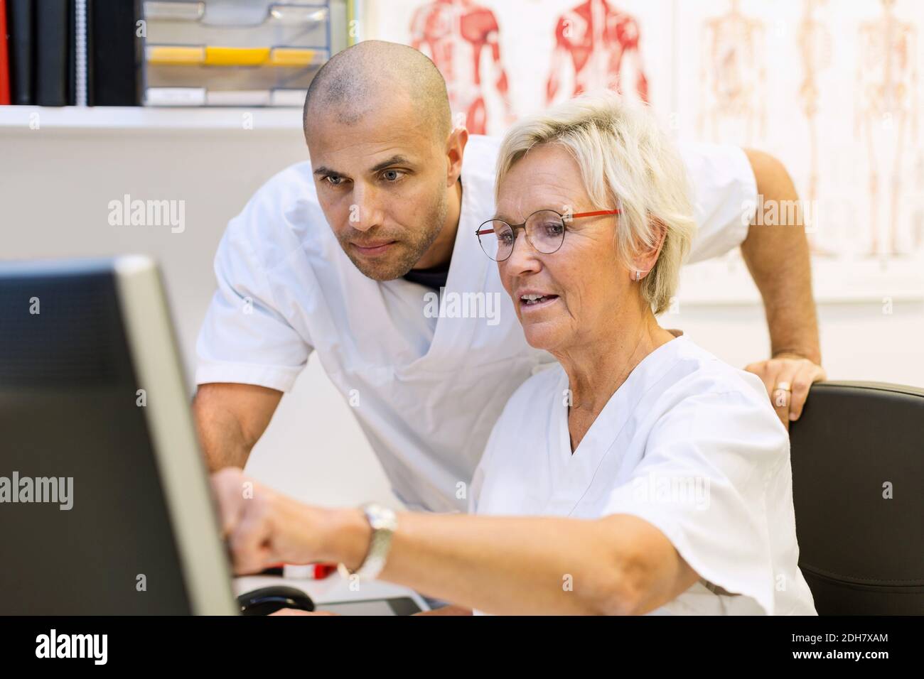 Doctors discussing over computer in office at orthopedic clinic Stock ...