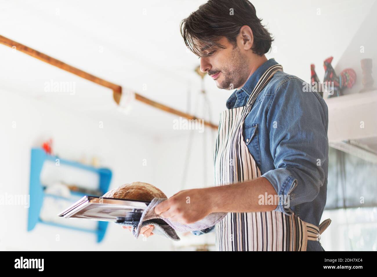 Side view of man holding freshly baked bread in tray at home Stock ...