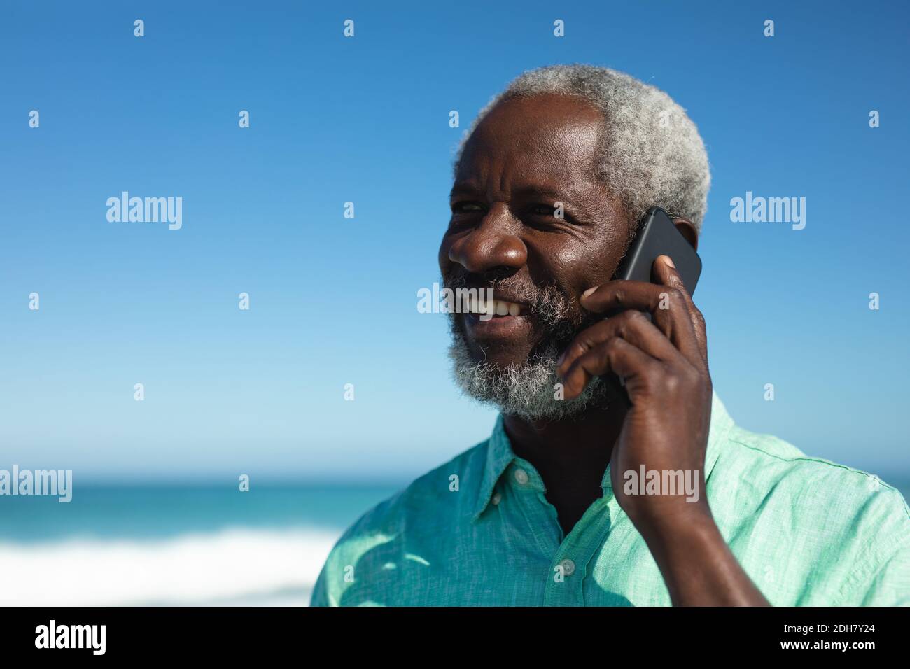 Old man using his phone at the beach Stock Photo - Alamy