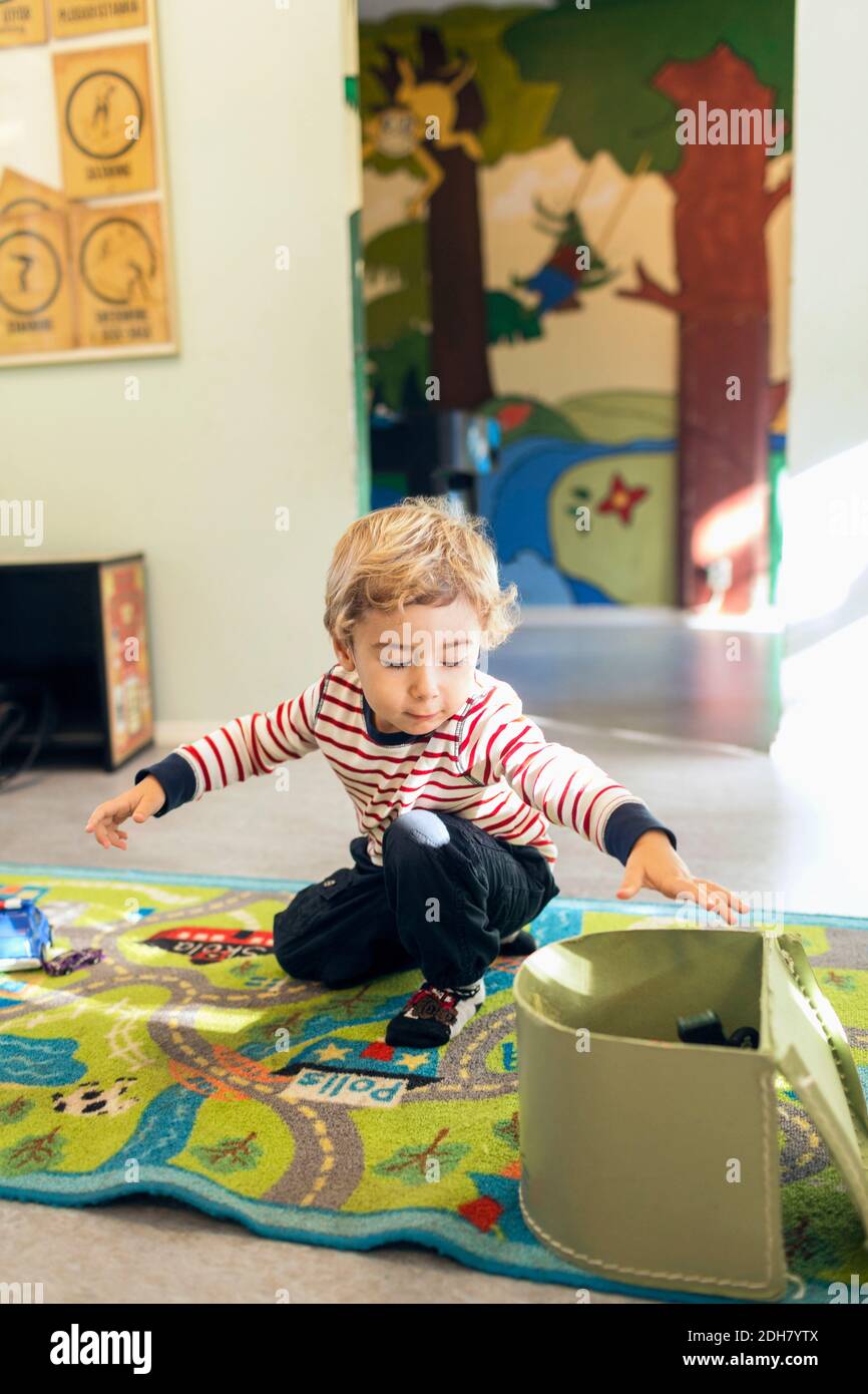 Boy removing toys from box in kindergarten Stock Photo - Alamy
