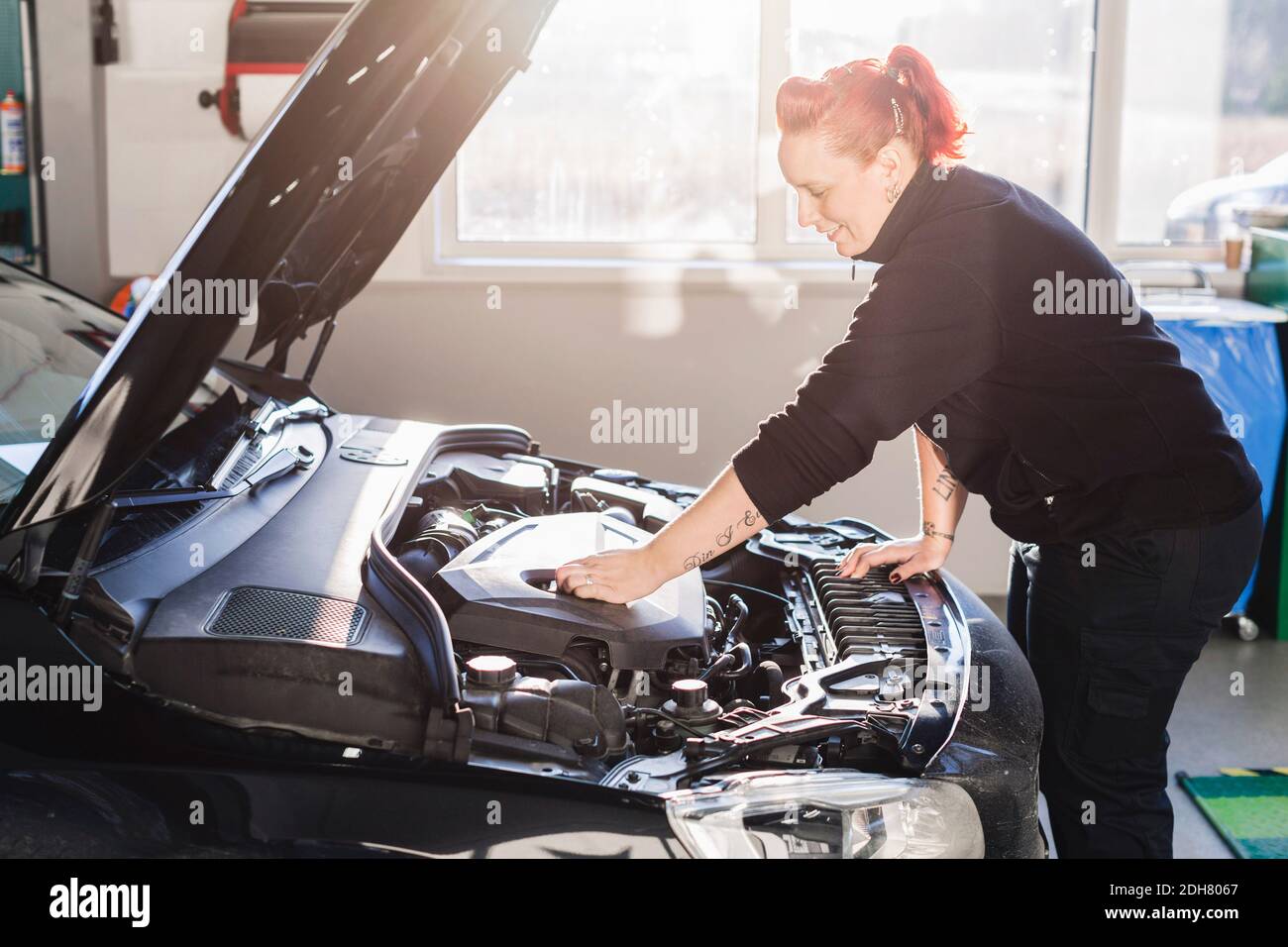 Female mechanic repairing car in auto repair shop Stock Photo - Alamy