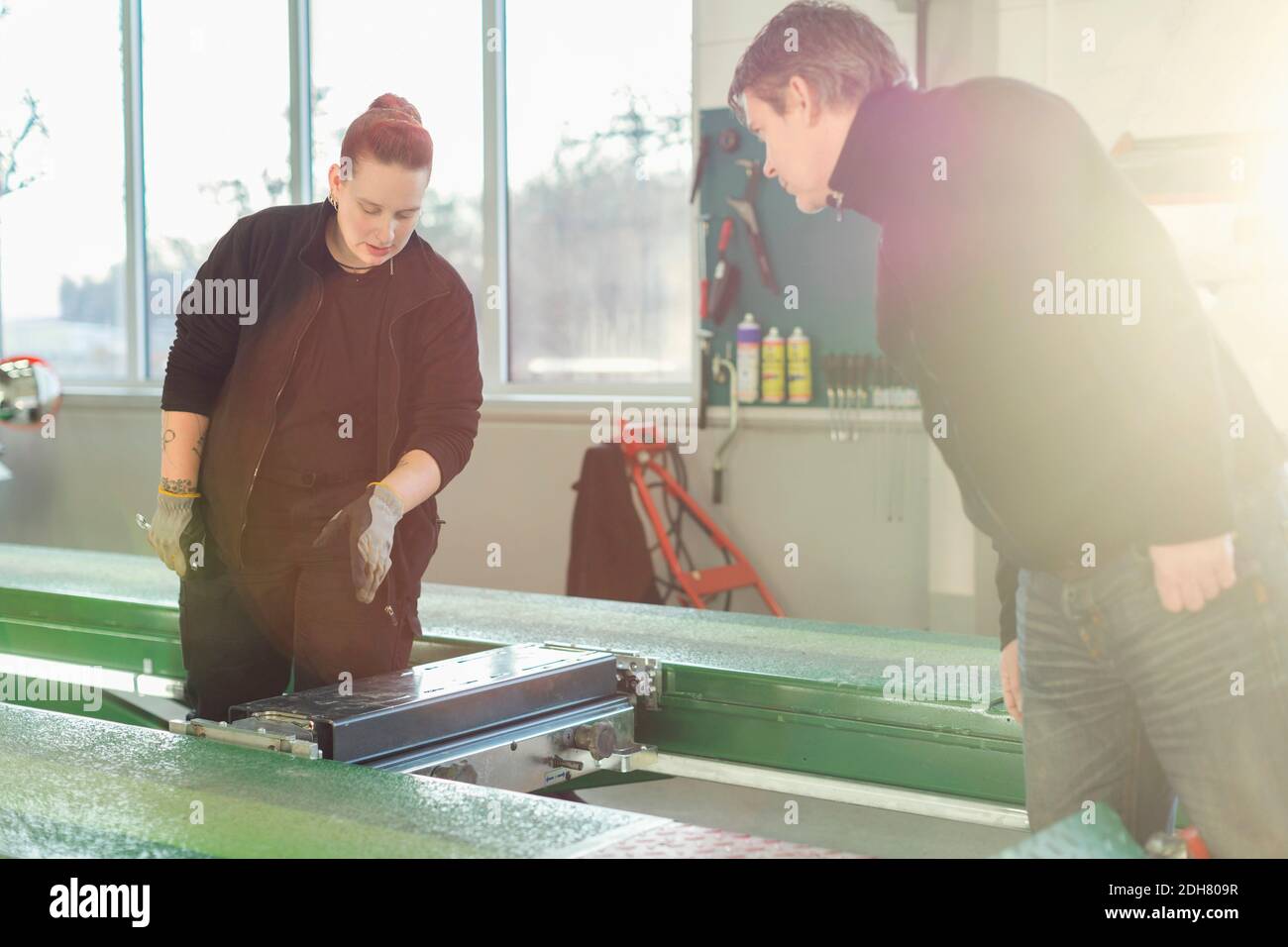 Mechanics operating hydraulic lift in auto repair shop Stock Photo - Alamy