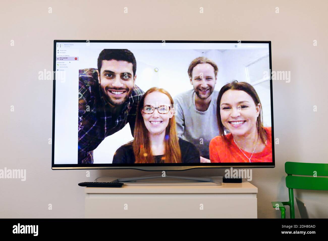 Happy business people on screen in video conference room at creative ...
