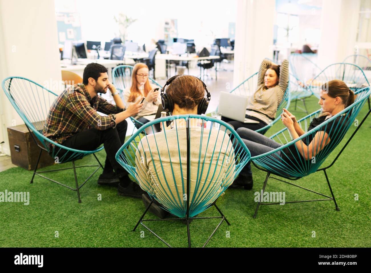Creative business people using technologies at office canteen Stock ...