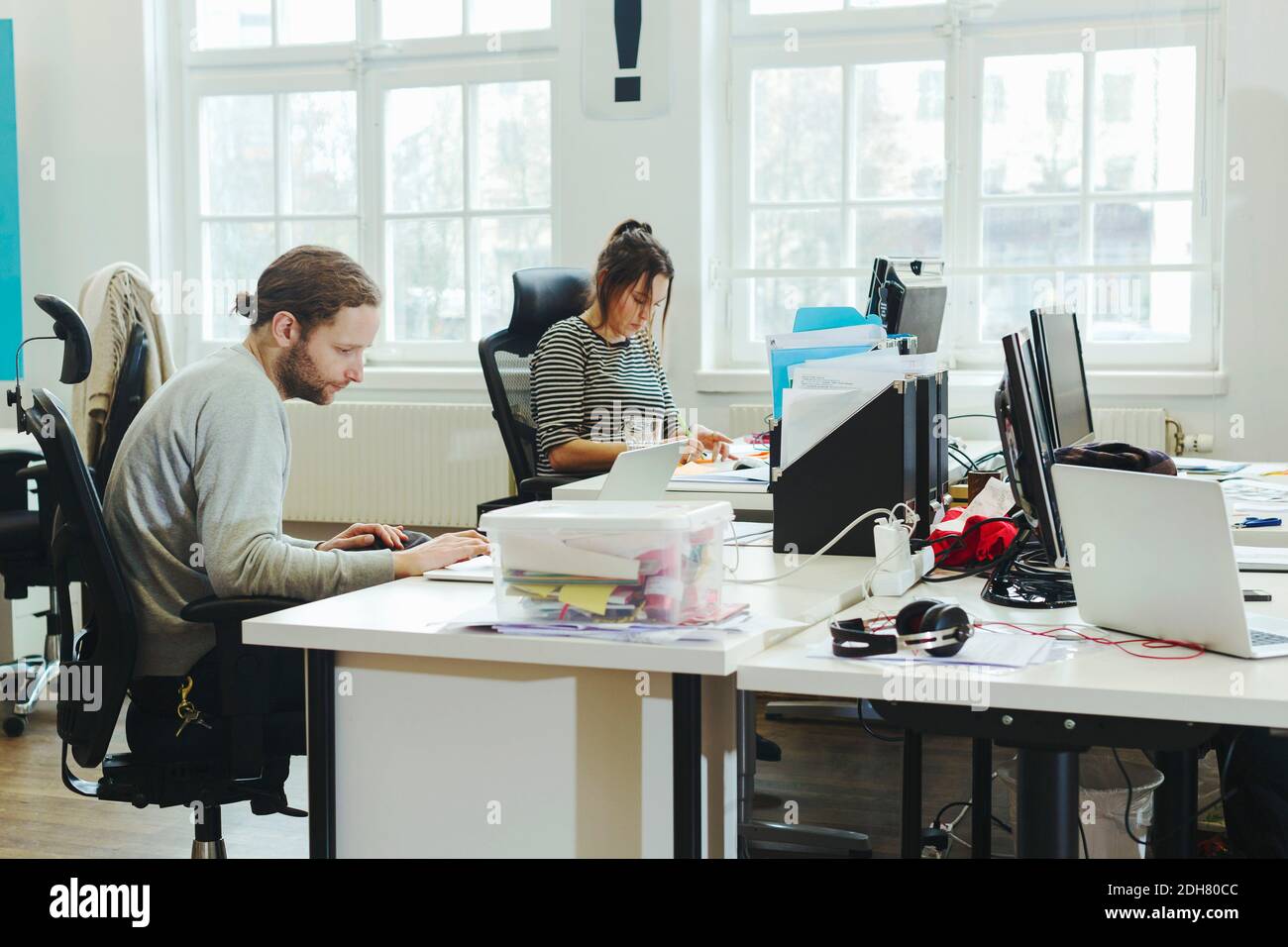 Business colleague working at computer desk in creative office Stock ...