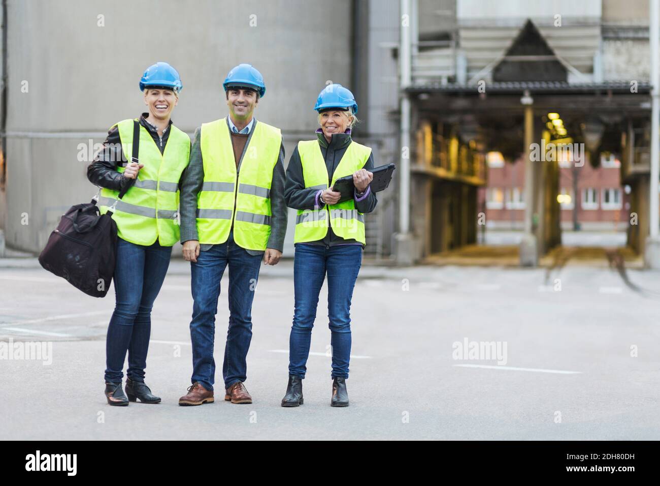 Full length portrait of happy manual workers at factory Stock Photo - Alamy