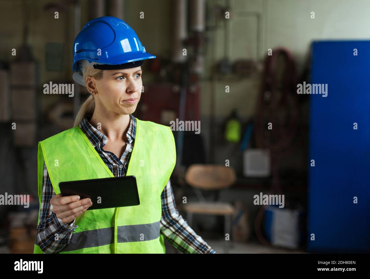 Female manual worker holding digital tablet in factory Stock Photo - Alamy