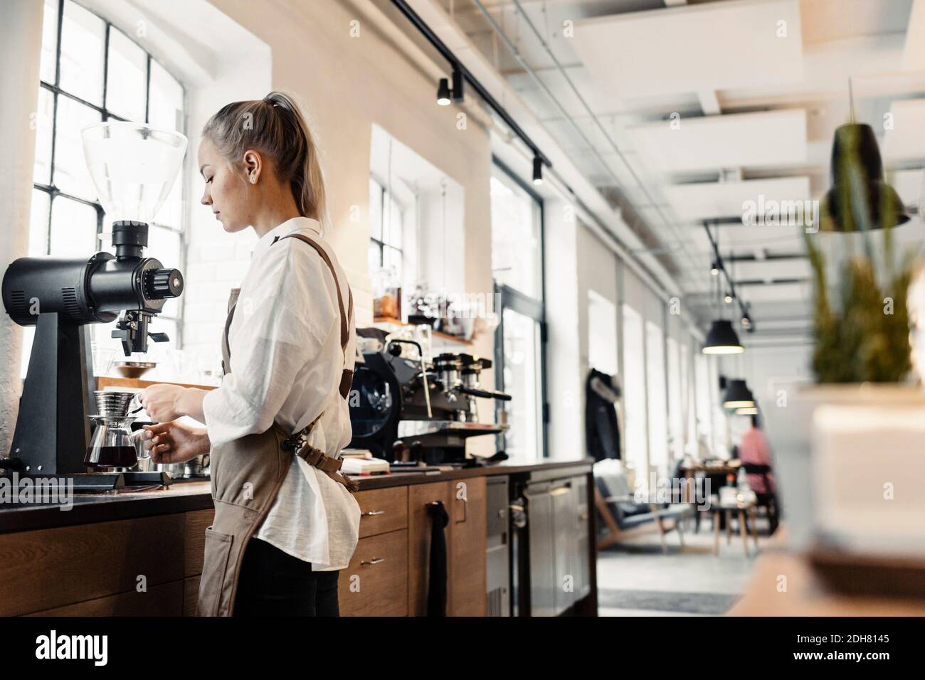 Side view of barista preparing coffee at counter at cafe Stock Photo ...