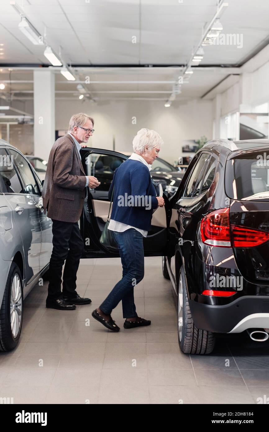 Senior couple examining car in store Stock Photo - Alamy