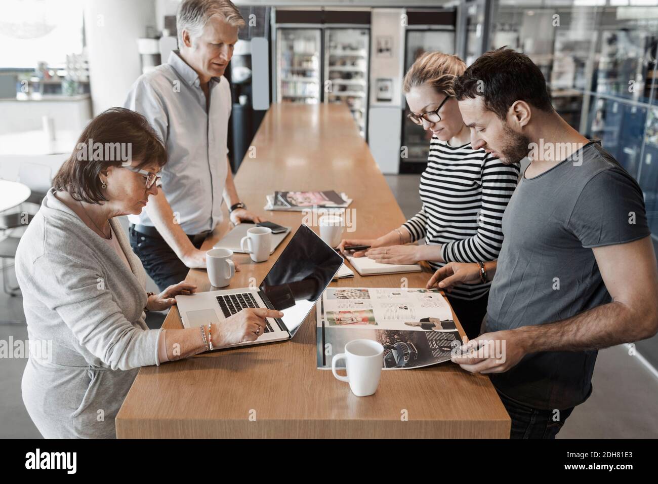 Multi-ethnic business people working at counter in office cafe Stock ...