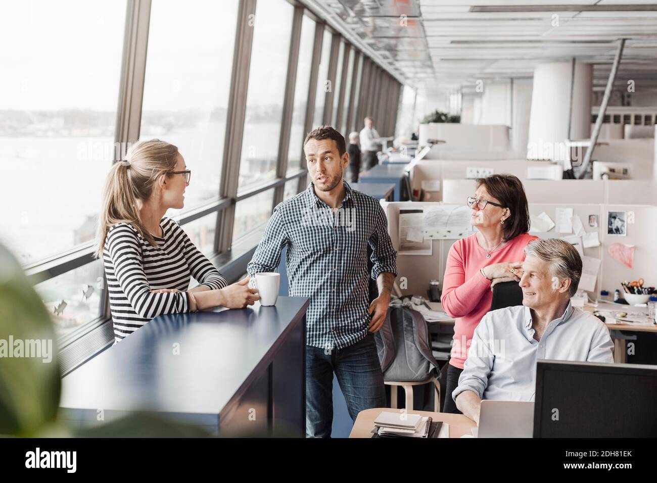 Business people discussing at cubicle in office Stock Photo - Alamy