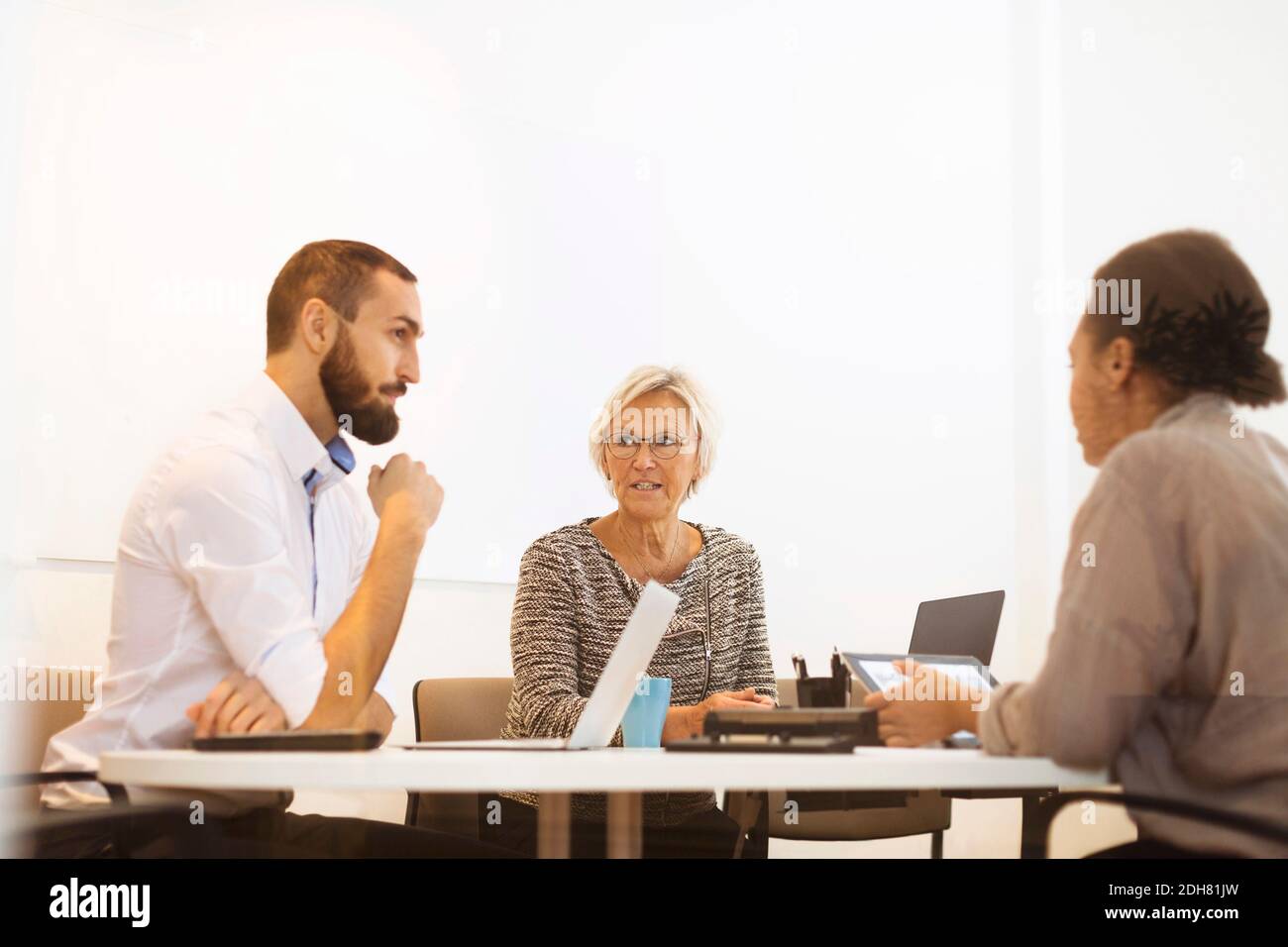 Businesspeople at conference table in office Stock Photo - Alamy