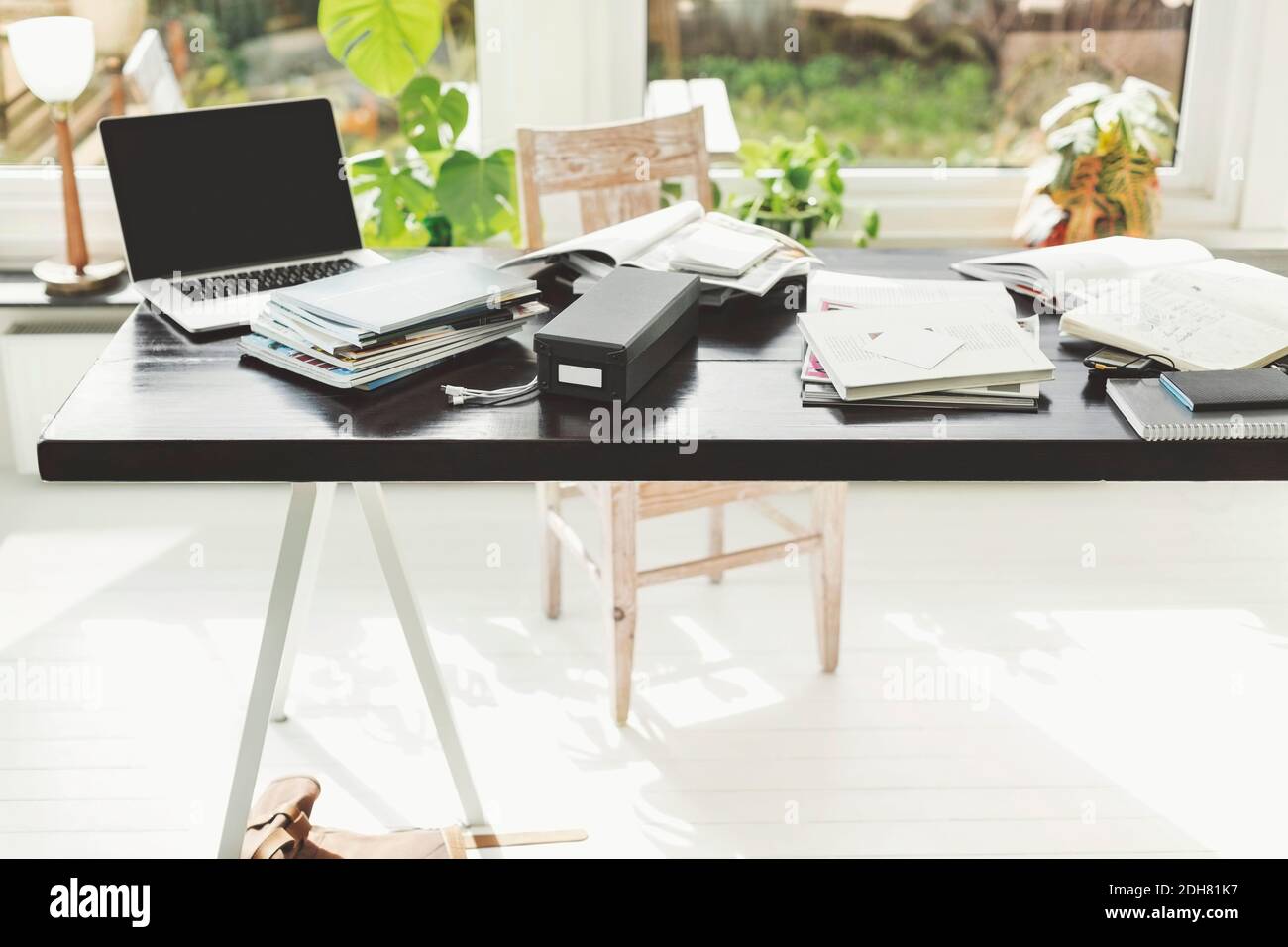 Books and laptop on table in home office Stock Photo - Alamy
