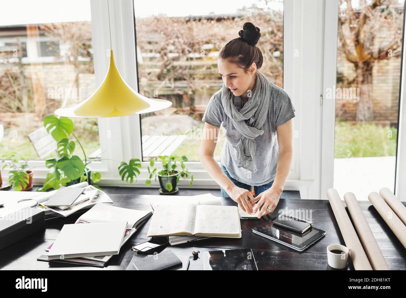 Female architect working at table in home office Stock Photo - Alamy